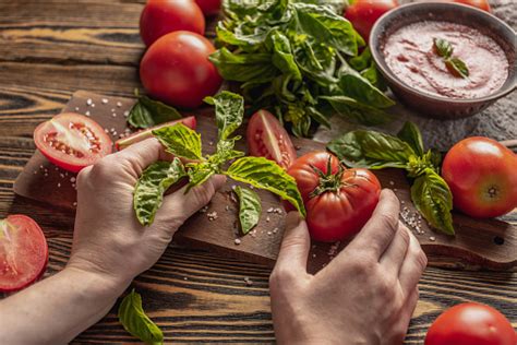 나무 테이블에는 신선한 전통 이탈리아 소스와 잘 익은 수제 토마토와 향기로운 바질을 들고있는 손이 담긴 그릇이 있습니다 건강한 식생활에 대한 스톡 사진 및 기타 이미지