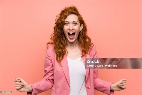 빨간 머리 여자 에 정장 위에 고립 된 핑크 벽 와 놀람 얼굴 표정 머리 모양에 대한 스톡 사진 및 기타 이미지 머리 모양