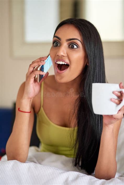 Indian Woman Bed And Surprised On Phone Call In Home With Coffee For Good News Or Conversation