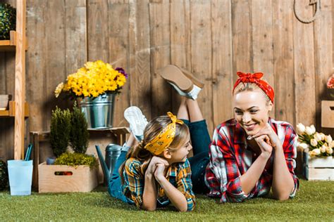 나무 울타리 근처 잔디에 교차 다리 누워 쾌활 한 어머니를 보고 딸 2명에 대한 스톡 사진 및 기타 이미지 2명 가족 꽃 식물 Istock