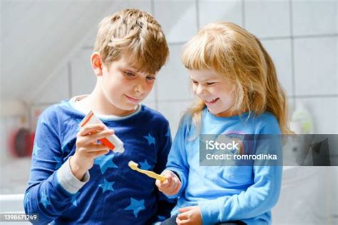 작은 유치원 소녀와 십대 학교 소년 양치질 치아 동생 은 양치질을 가르치는 형제 행복한 형제 자매 아침 치과 루틴으로 재미를 가진 두 아이 실내가족 2명에 대한 스톡 사진
