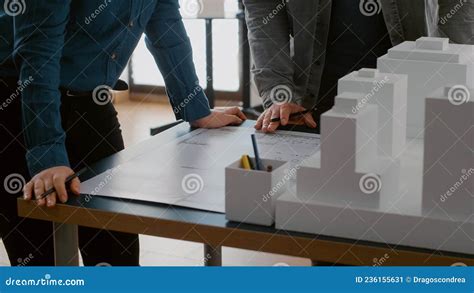 Close Up Of Colleagues Working On Urban Design With Blueprints And Building Model Stock Image