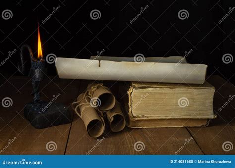 ancient unfolded and rolled scrolls ancient books and a burning candle