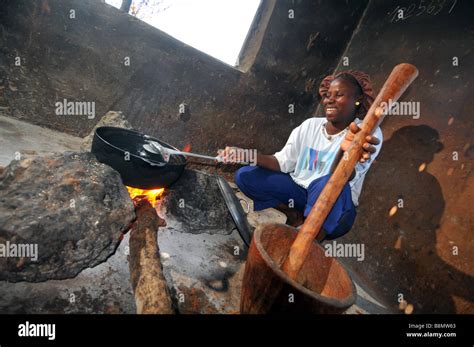Woman Cooking Over An Open Fire In Her Basic Rural Village Kitchen The