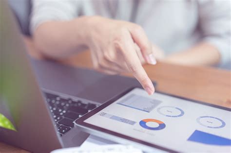 젊은 매니저 여성 사업가가 디지털 태블릿의 통계 차트 대시보드 화면을 가리키며 비즈니스 및 재무 개념을 위한 사무실에서 투자 및 마케팅 성과에 대해 묻고 추정합니다 가정의