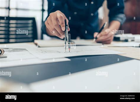 Architect Using Divider Compass Working On Blueprint And Make A Note On