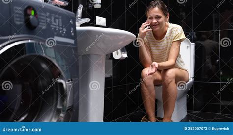 Happy Woman Speaks On Smartphone While Sitting On Toilet Stock Video
