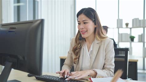 헤드폰을 착용한 아시아 여성 고객 지원 에이전트 또는 콜센터의 웃는 얼굴과 사무실의 데스크톱 컴퓨터에서 작업 고객에 대한 스톡 사진 및 기타 이미지 Istock