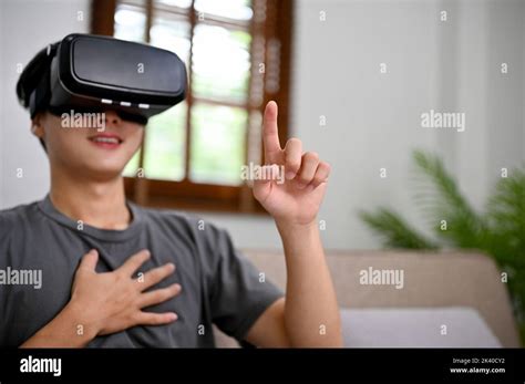 Excited And Joyful Young Asian Man Wearing Vr Goggles Playing