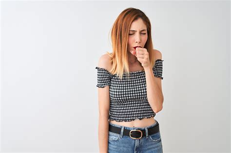 고립 된 흰색 배경 위에 서있는 캐주얼 한 빨간 머리 여성은 감기 또는 기관지염의 증상으로 기분이 좋지 않고 기침합니다 헬스케어 개념 T 셔츠에 대한 스톡 사진 및 기타