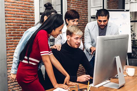 데스크톱 컴퓨터와 캐주얼 비즈니스 작업 및 토론 전략의 그룹 창의적인 비즈니스 사람들은 현대적인 워크 로프트에서 계획 하 고 브레인스토밍 합니다 팀워크 컨셉 기업 비즈니스에