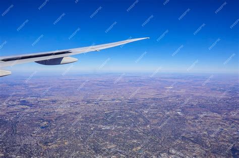 Premium Photo An Airplane Wing Over Blue Sky