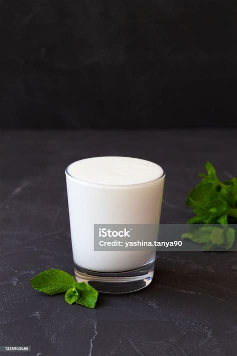 신선한 녹색 민트와 함께 라시 음료 차가운 유제품 인도 요리 복사 공간을 복사합니다 아일란 어두운 테이블에 프로바이오틱스를 곁들인 우유 건강하고 발효 된 제품 개념 세로