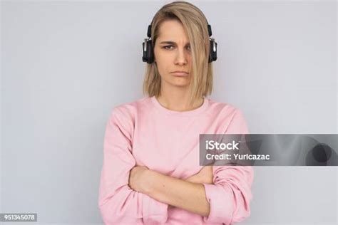 심 술 젊은 여성의 머리 나쁜 건강 한 음악 불만된에 헤드폰으로 분홍색 스웨터를 입고 스튜디오 초상화 흰 벽 배경에 고립 텍스트 광고에 대 한 공간을 복사 합니다 샐쭉한에