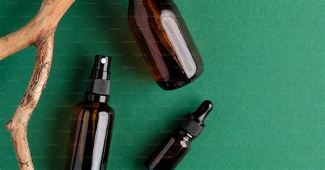 녹색 배경에 천연 화장품과 나무 가지가 있는 호박색 유리 패키지 플랫 레이 평면도 바이오 유기농 제품 아름다움과 스파 개념 사진 Unsplash의 포장 이미지