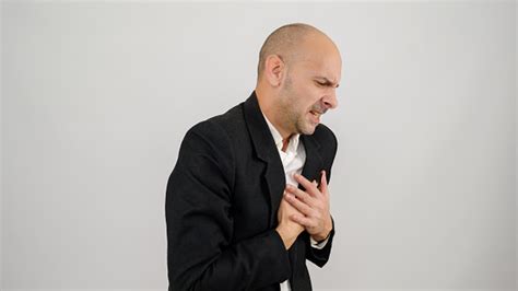 스튜디오에서 양복을 입은 중년 사업가가 하얀 배경 앞에 서서 심장마비를 일으키는 것처럼 가슴에 손을 얹고 있다 40 44세에 대한 스톡 사진 및 기타 이미지 Istock