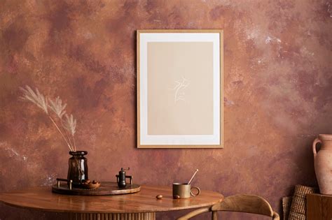 포스터 모형과 보호 식당 인테리어의 인테리어 디자인 나무 쟁반이있는 원형 테이블 말린 꽃과 컵이있는 꽃병 갈색 벽과 등나무 램프 포스터를 모의하십시오 템플렛 가구에 대한