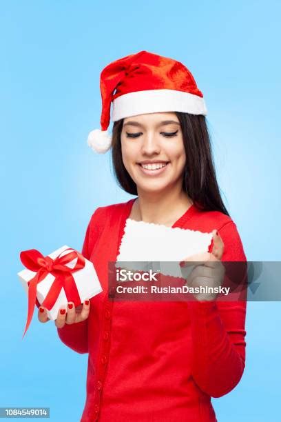 인사말 카드 읽기 산타 모자에 아름 다운 여자 레드 리본으로 흰색 선물 상자를 들고 12월에 대한 스톡 사진 및 기타 이미지