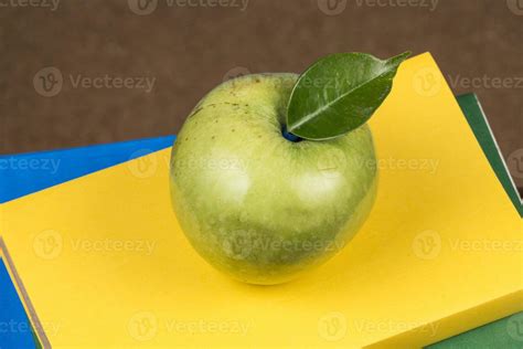 Apple Fruit On Top Of A Book Stack On The Back Of School Classes