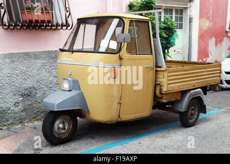 A Piaggio Ape Three Wheeled Truck Is Driven Through A Small Italian