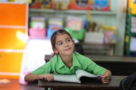Premium Photo Girl Looking Away While Sitting At Table In Classroom