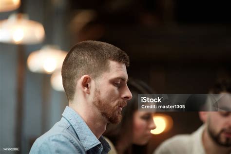 젊은 진지한 남자 동료들과 사무실에서 회의에 앉아 있는 직원의 클로즈업 이미지 사람들과 흐릿한 배경 20 24세에 대한 스톡