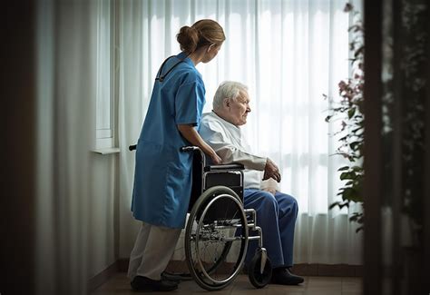 Foto van een vrouwelijke verpleegster de patiënt helpt om de oude patiënt geeft