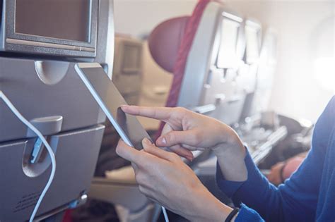 현대 비행기 좌석에서 휴대 전화를 사용 하는 여자입니다 Usb 케이블에 대한 스톡 사진 및 기타 이미지 Usb 케이블 관광 관광객 Istock