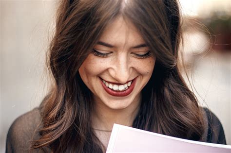 아름 다운 세련 된 Hipster 소녀 도시 거리 웃 고 잡지 들고 세련 된 옷 편안 하 고 유럽 도시에서 시간을 즐기는 행복 한 화려한 여자 초상화 입고 갈색 머리에 대한