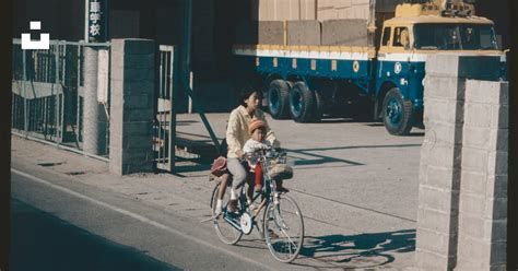 자전거를 타고 노란 트럭 옆 거리를 달리고 있는 한 남자 사진 Unsplash의 무료 도시 이미지