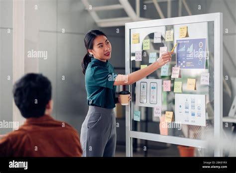 Asian Ux Developer And Ui Designer Presenting Mobile App Interface