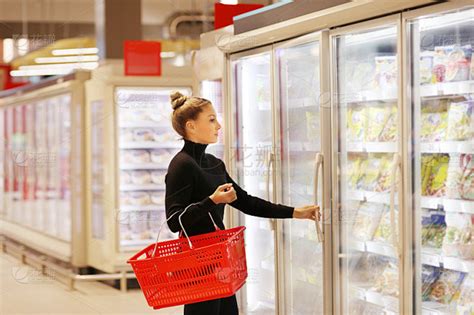 从超市冰箱里挑选冷冻食品的女人