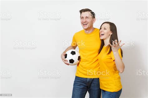 재미 있는 미친 쾌활 한 감정 젊은 부부 여자 남자 노란색 유니폼 응원 축구공 흰색 배경에 고립 된 지원 팀에서 축구 팬 들 스포츠 가족 레저 라이프 스타일 개념 2018