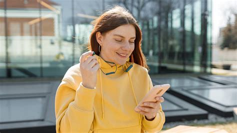 거리에서 헤드폰을 통해 음악을 듣는 젊은 여성 꽤 행복한 빨간 머리 여자는 도시 배경에 서서 휴대 전화를 들고 있습니다 30 34세에 대한 스톡 사진 및 기타 이미지