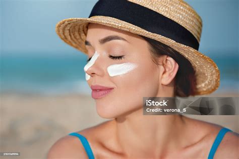 얼굴에 선크림을 바른 아름 다운 젊은 여자 모자에 모이스처라이징 로션을 바르는 여성 스킨 케어 자외선 차단 선탠 햇볕 차단 로션에 대한 스톡 사진 및 기타 이미지 Istock