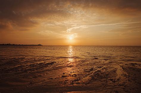 海に落ちていく夕陽にハートの手をかざす女の子のフリー画像｜おしゃれなフリー写真素材：girly Drop