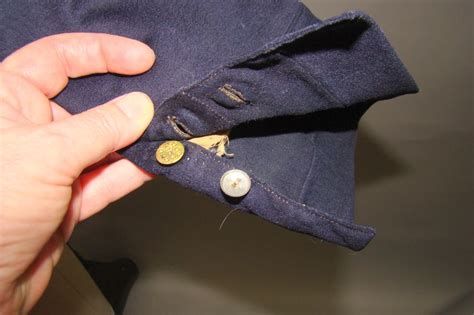 close up of cuffs one of the buttons has lost it s cap these buttons