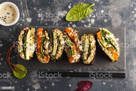 두 부와 야채 채식 초밥 샌드위치 Onigirazu입니다 두 부 고구마 아보카도 및 Tahini와 함께 화려한 일본 샌드위치 Onigirazu 추세 채식주의 음식 개념입니다