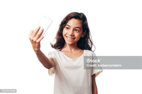 휴대 전화를 들고 웃 고 있는 작은 소녀의 초상화와 흰색 배경 위에 고립 된 셀 카 만들기 귀여운에 대한 스톡 사진 및 기타