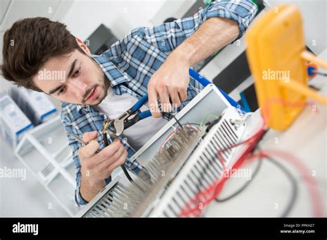 Man Holding Tools While Fixing A Device Stock Photo Alamy