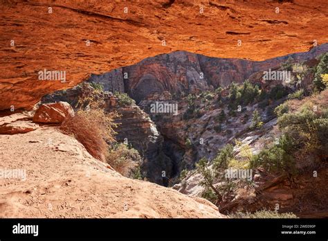 A Rock Overhang Forms A Cave Overlooking A Steep Drop Off Into The