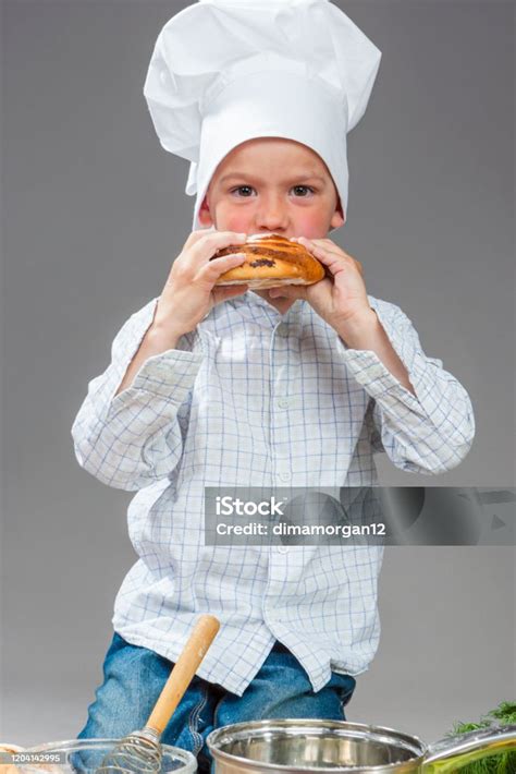 식품 개념 계피와 함께 신선한 빵을 먹는 행복한 백인 작은 소년의 초상화 요리 모자 Agaunst 회색 배경에서 포즈 수직 이미지 컴포지션 도넛에 대한 스톡 사진 및 기타