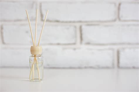 Diffuser Aroma Aroma Rumah Dengan Tongkat Bambu Di Atas Latar Belakang Dinding Bata Putih Dengan