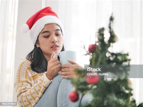 아시아 여자 입고 산타 모자와 들고 커피 컵 창 밖을 보면 라이프 스타일 개념에 대한 스톡 사진 및 기타 이미지 개념 개념과 주제 겨울 Istock