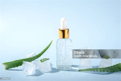 하늘색 배경에 스포이드 얼음 조각 알로에 잎이 있는 투명한 화장품 병 알로에 베라 추출물 노화 방지 피부 관리 보습 및 클렌징의 개념 공간을 복사합니다 몸 가꾸기에 대한