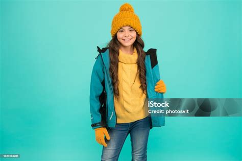 평온한 어린 시절 귀여운 소녀는 겨울 시즌을 즐길 수 있습니다 어린 아이는 니트 모자를 착용합니다 겨울 방학 보호 옷 겨울 컬렉션 아이 착용 모자 장갑 재킷 활동적인 레저