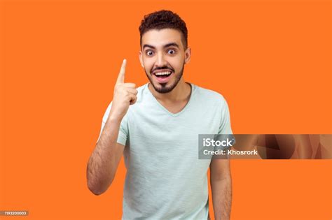 흰색 티셔츠에 수염을 가진 영감 잘 생긴 갈색 머리 남자의 초상화 손가락을 가리키는 오렌지 배경에 고립 된 실내 스튜디오 샷 남자에 대한 스톡 사진 및 기타 이미지 Istock