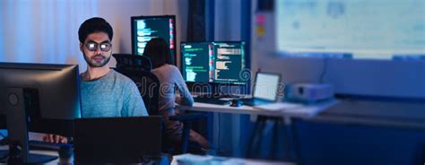 asian software developers working on multiple screens displaying code