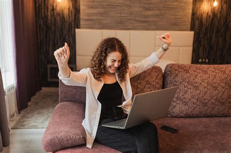 전자 상거래 학생은 노트북에서 작업합니다 컴퓨터에서 집에서 일하는 빨간 머리 곱슬 소녀 미친 사람은 좋은 일을 즐길 수 있습니다 비즈니스 프로젝트에서 승리 즐거운 감정