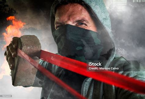 젊은 남자로 울트라 와 급진적 인 무정부 주의자 리오터 보라색 폭동과 혼돈의 시위에 거리에서 적대적인 벽돌을 던지는 얼굴 마스크에 분노 안티 파 시위자 반파시즘에 대한 스톡